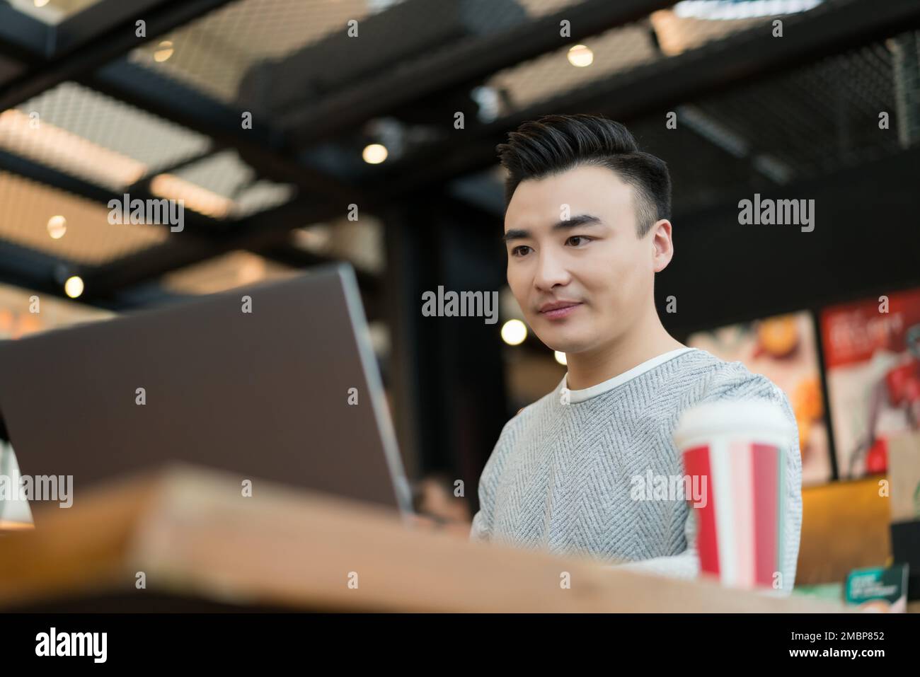 Young men who use a computer in a restaurant Stock Photo - Alamy