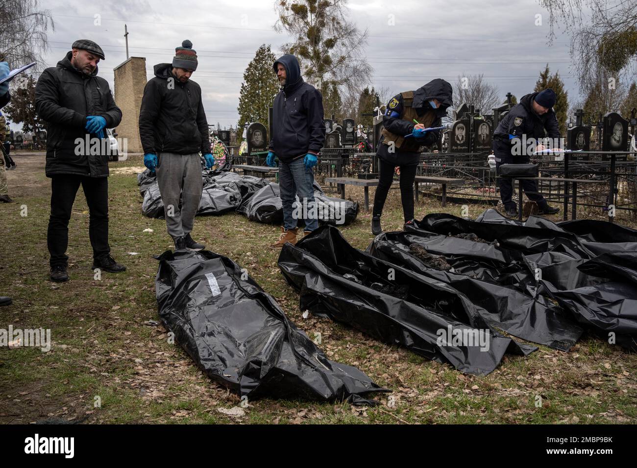 Policemen collect information next to corpses of civilians killed in ...