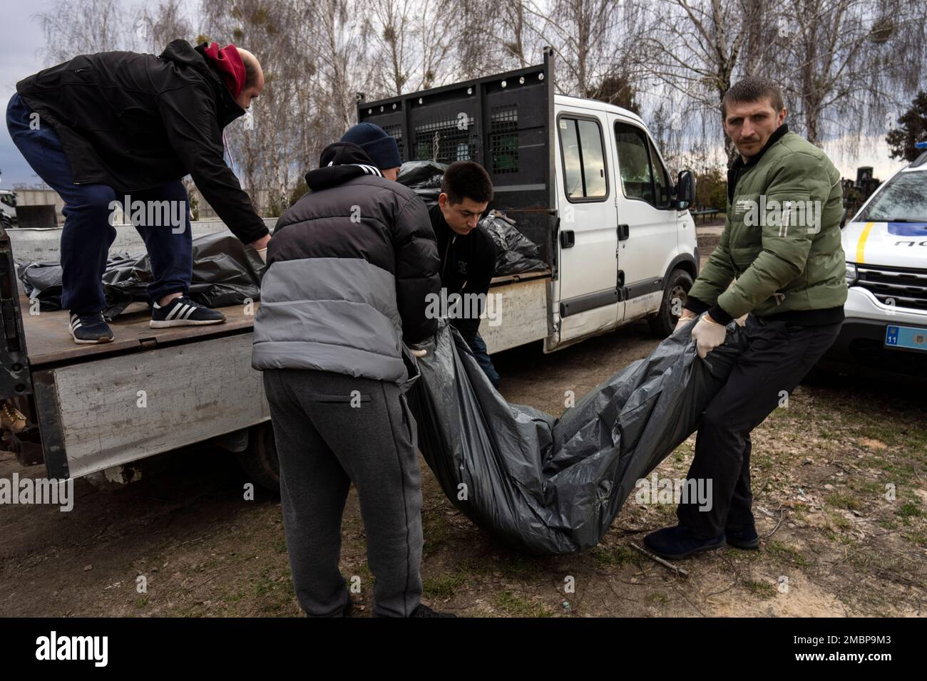 Cemetery workers lift three corpses of civilians killed in Bucha, to be ...