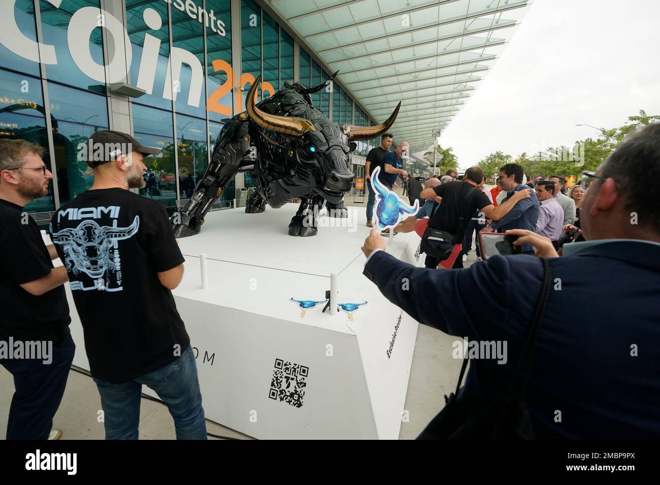 Attendees at the Bitcoin 2022 conference take photos of the Miami Bull ...