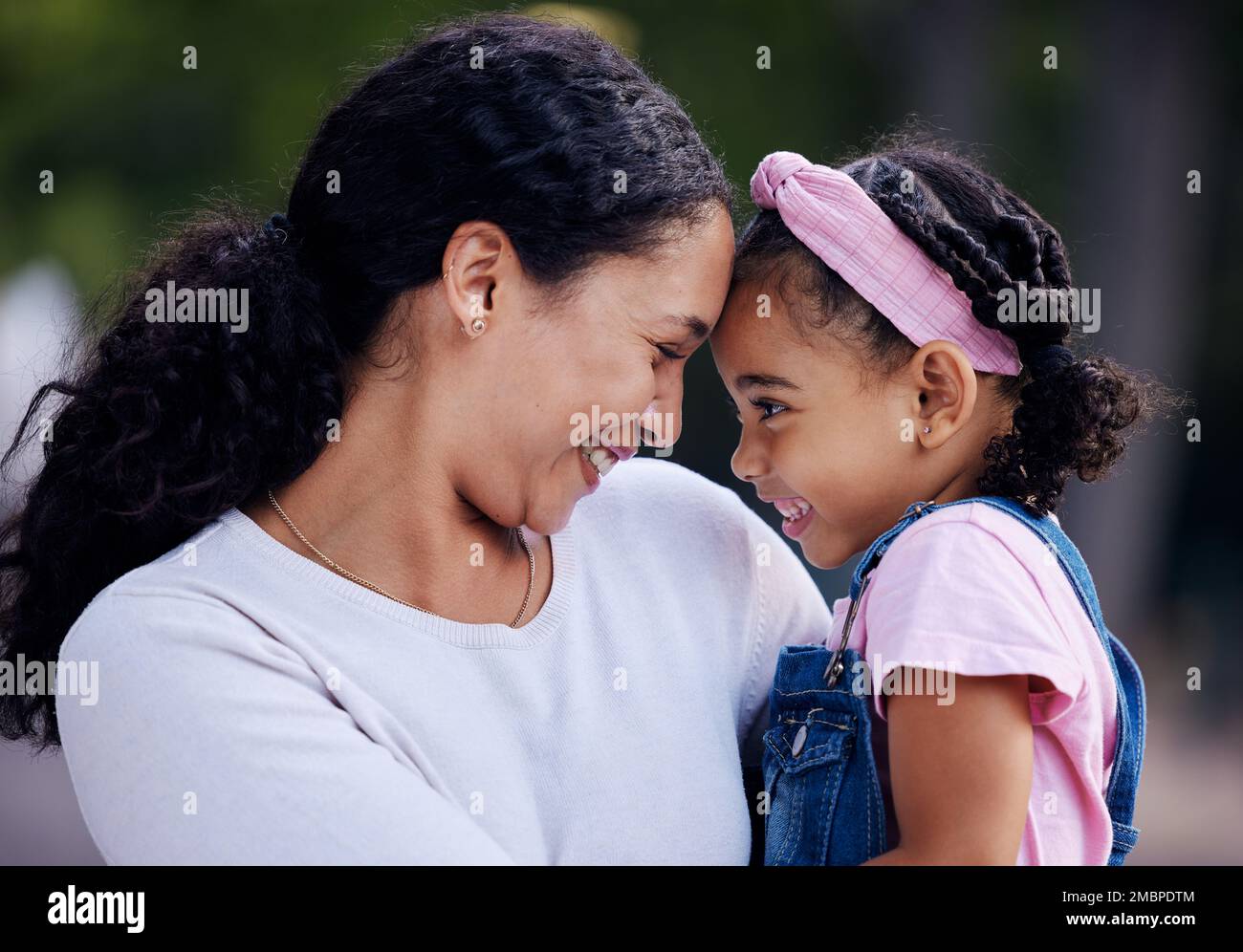 Mother, daughter and hug in a park, love and sweet while bonding outdoor together. Black woman ...