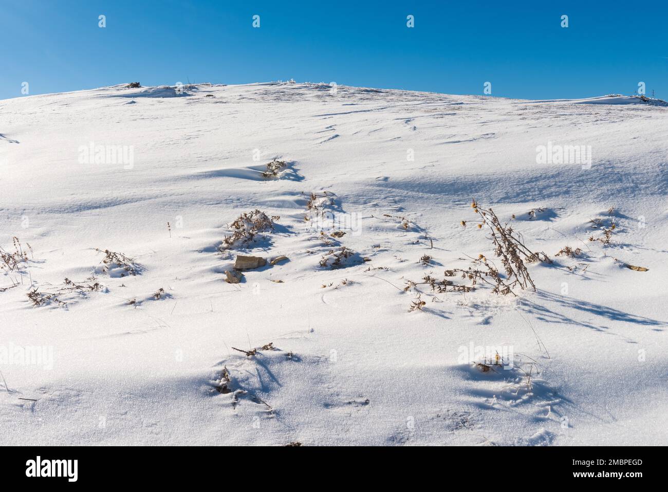 Snow covered hill and blue sky Stock Photo - Alamy