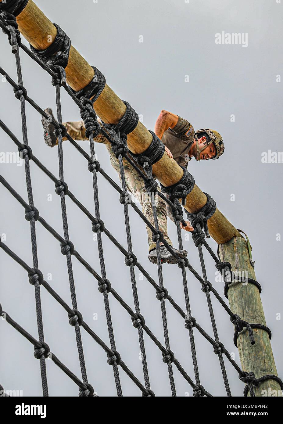 A United States team member climbs over an obstacle during the obstacle ...