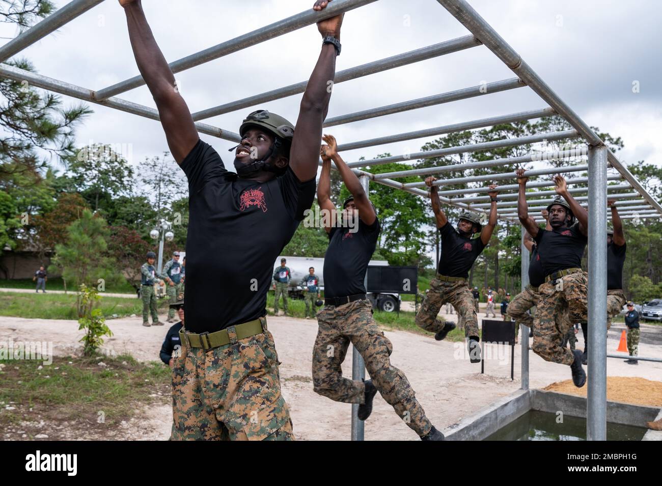 Partner nation team members participate in the obstacle course as part ...