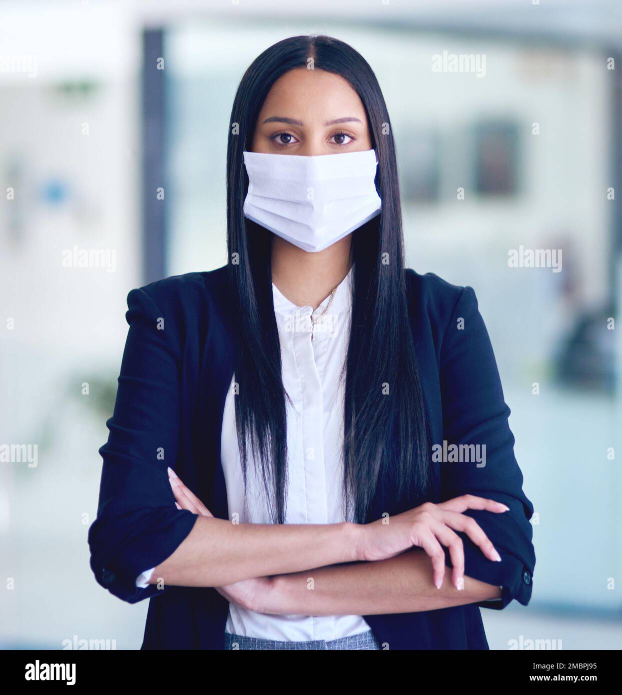 Be aware, take care. Portrait of a young businesswoman wearing a face ...