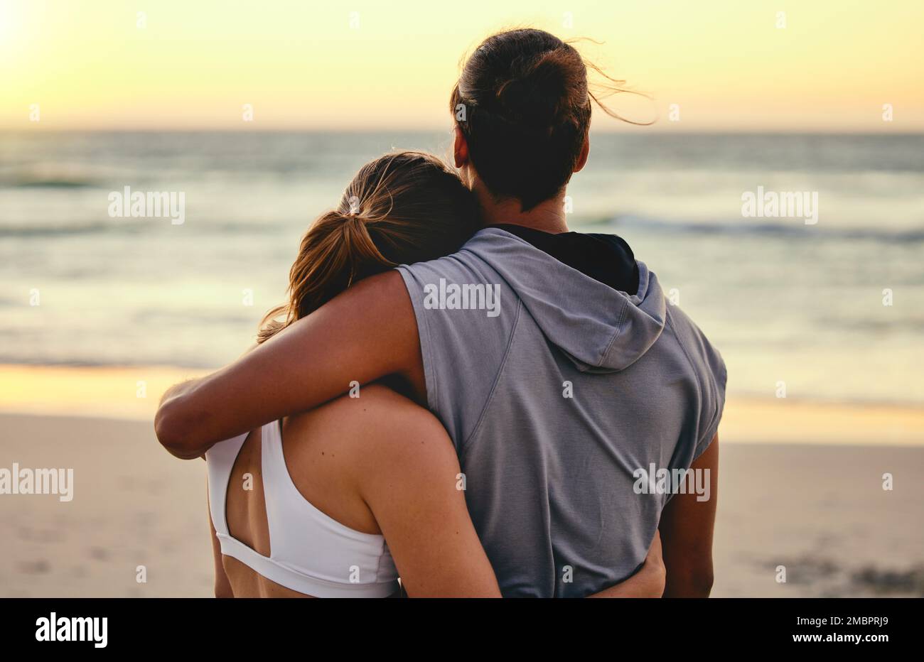 Hug, fitness and back of couple at the beach for sunset training ...