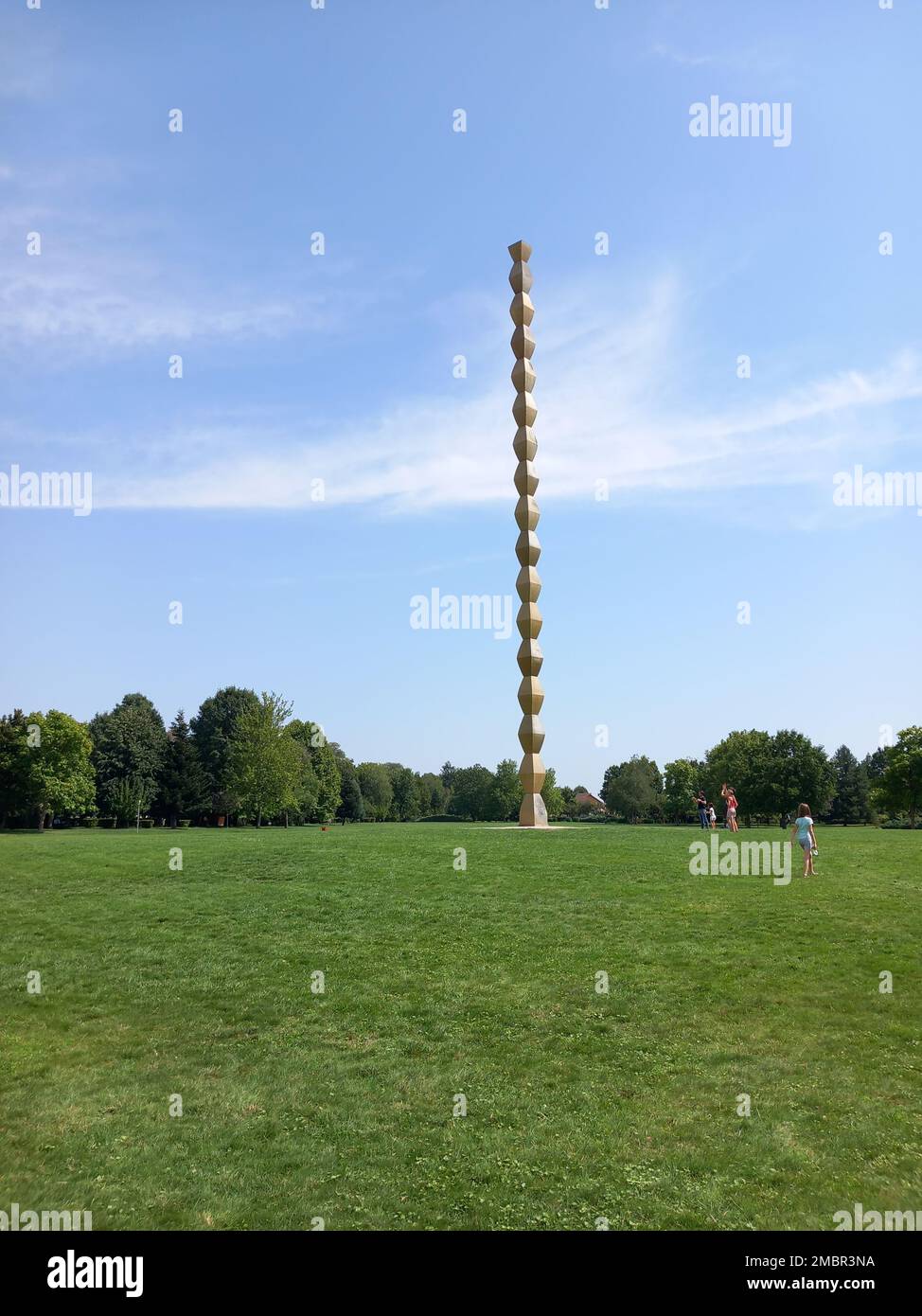 A vertical shot of Infinity Column monument against blue sky in a park ...
