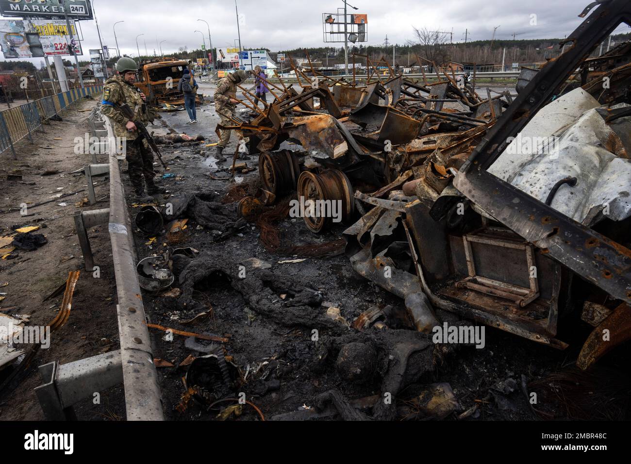 EDS NOTE: GRAPHIC CONTENT - A Ukrainian soldier looks at the charred ...