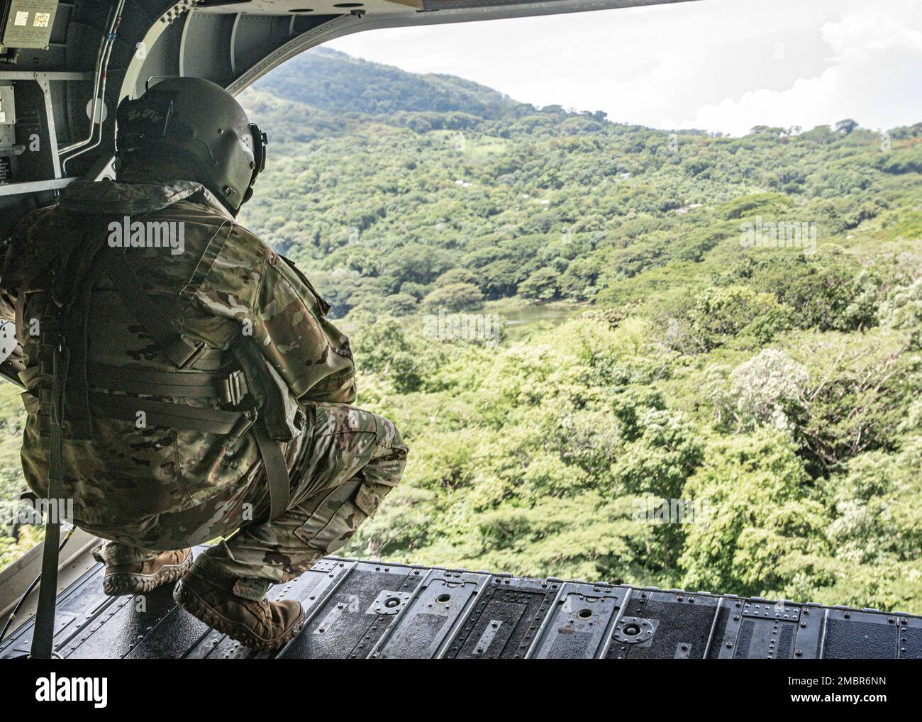 An Army loadmaster observes below a CH-47 Chinook during the water and ...