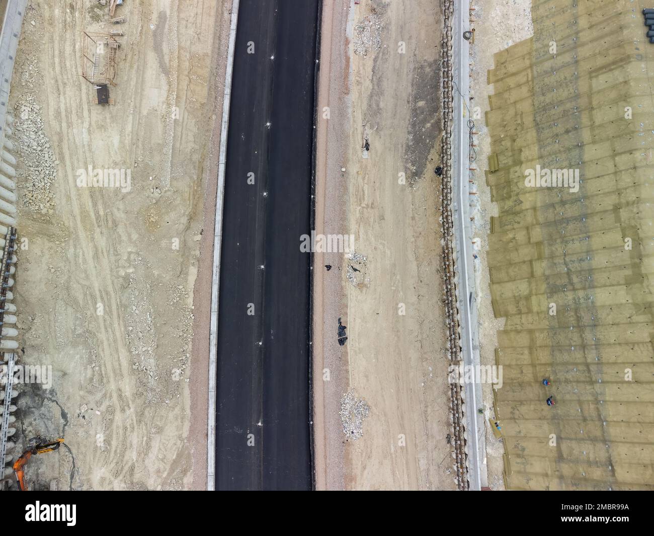 Mountain road constraction. Workers reinforce the slope over the new ...