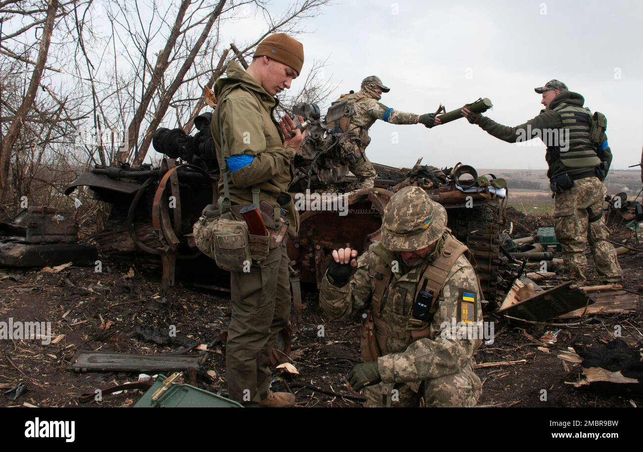 Ukrainian servicemen inspect a destroyed armoured vehicle near the ...