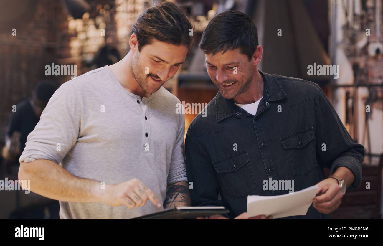 Using technology to visualise their ideas. two men discussing paperwork ...