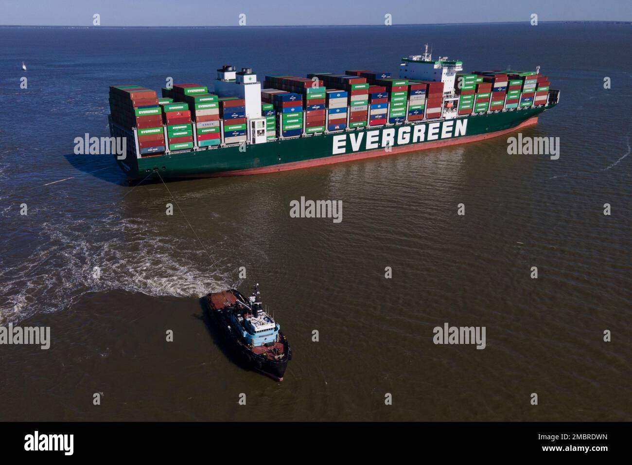 The tugboat Atlantic Salvor, bottom, uses a line to pull the container ...