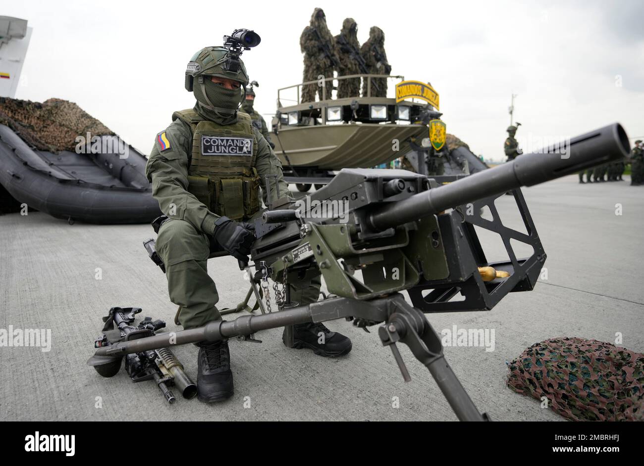 An anti-narcotics police officer sits with a grenade launcher during a ...