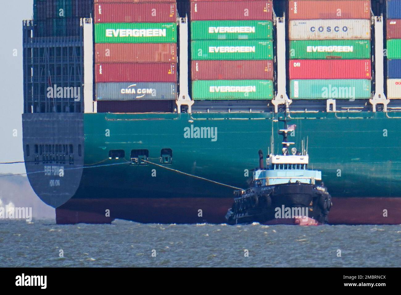 The tugboat Atlantic Salvor, bottom, uses a line to pull the container ...
