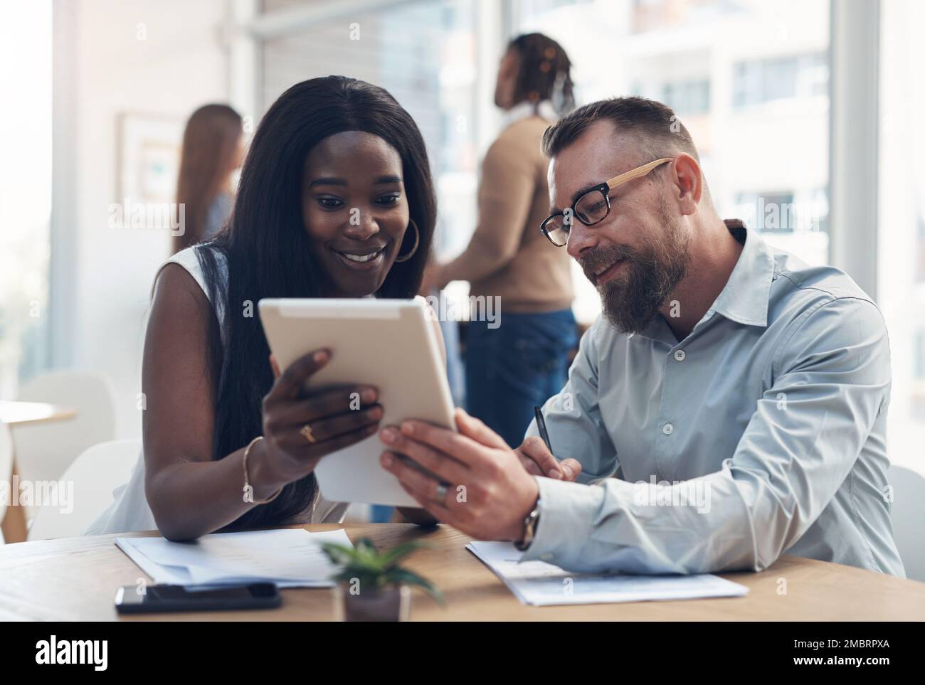 We work better when we work together. two young businesspeople sitting ...
