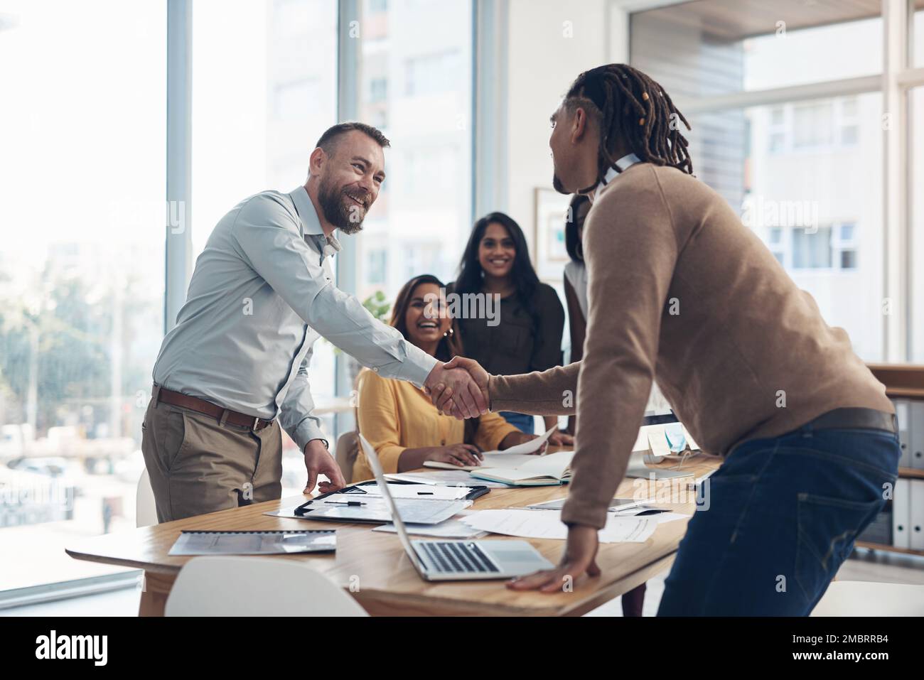 Welcome to the team. two handsome businessmen shaking hands during a ...