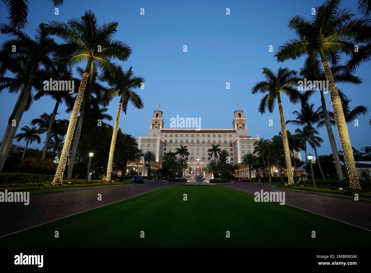 Palm trees adorned with fairy lights line the drive to The Breakers ...