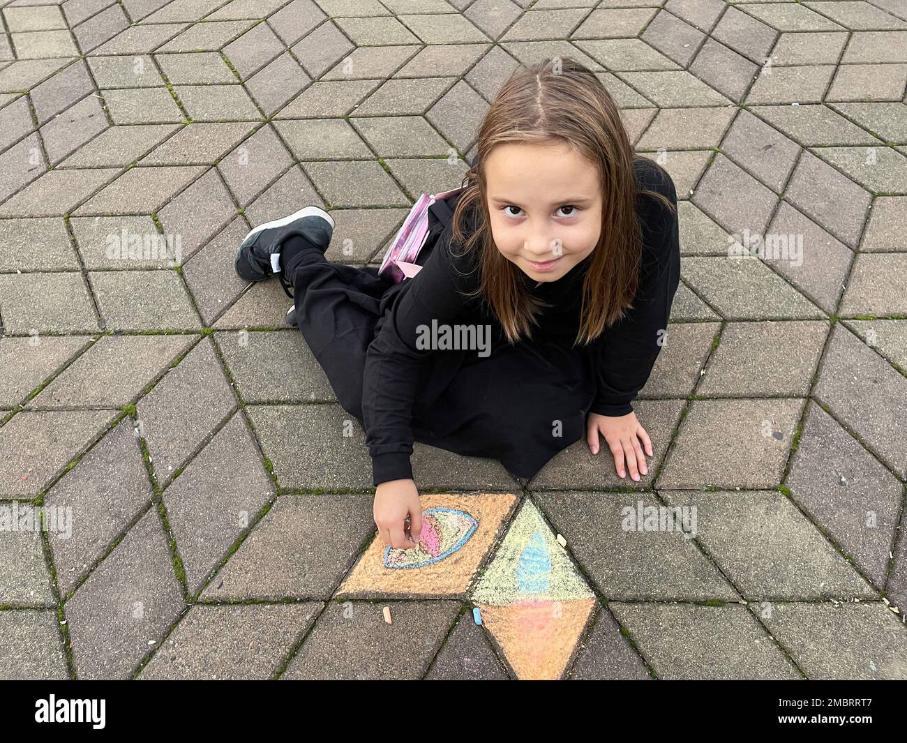 Little child young girl drawing with chalk on asphalt outdoors Stock ...