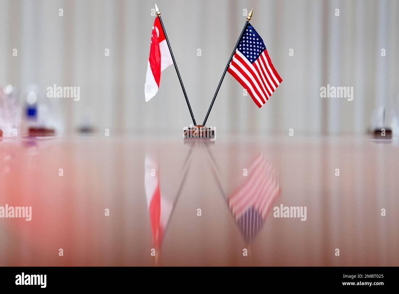 A Singaporean and an American flag are displayed during a meeting ... A Singaporean and an American flag are displayed during a meeting ...