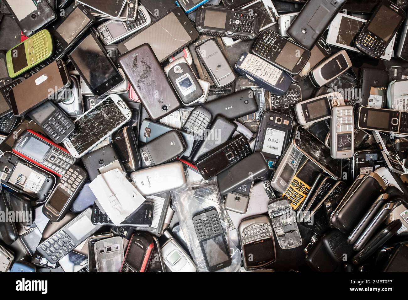 FILE - Discarded mobile phones fill a bin at the Out Of Use company ...