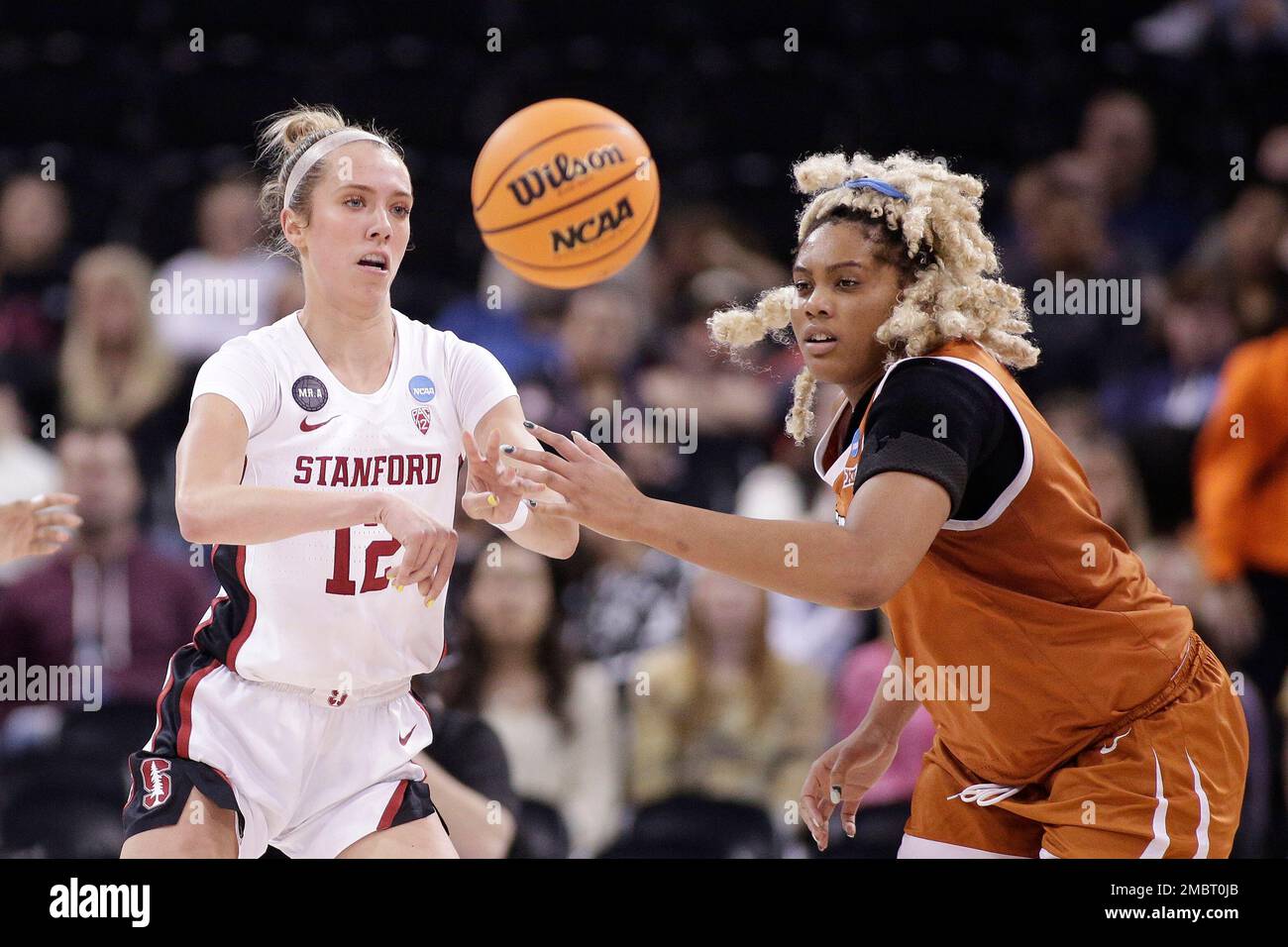 Stanford guard Lexie Hull, left, passes the ball past Texas center Lauren Ebo during a college ...