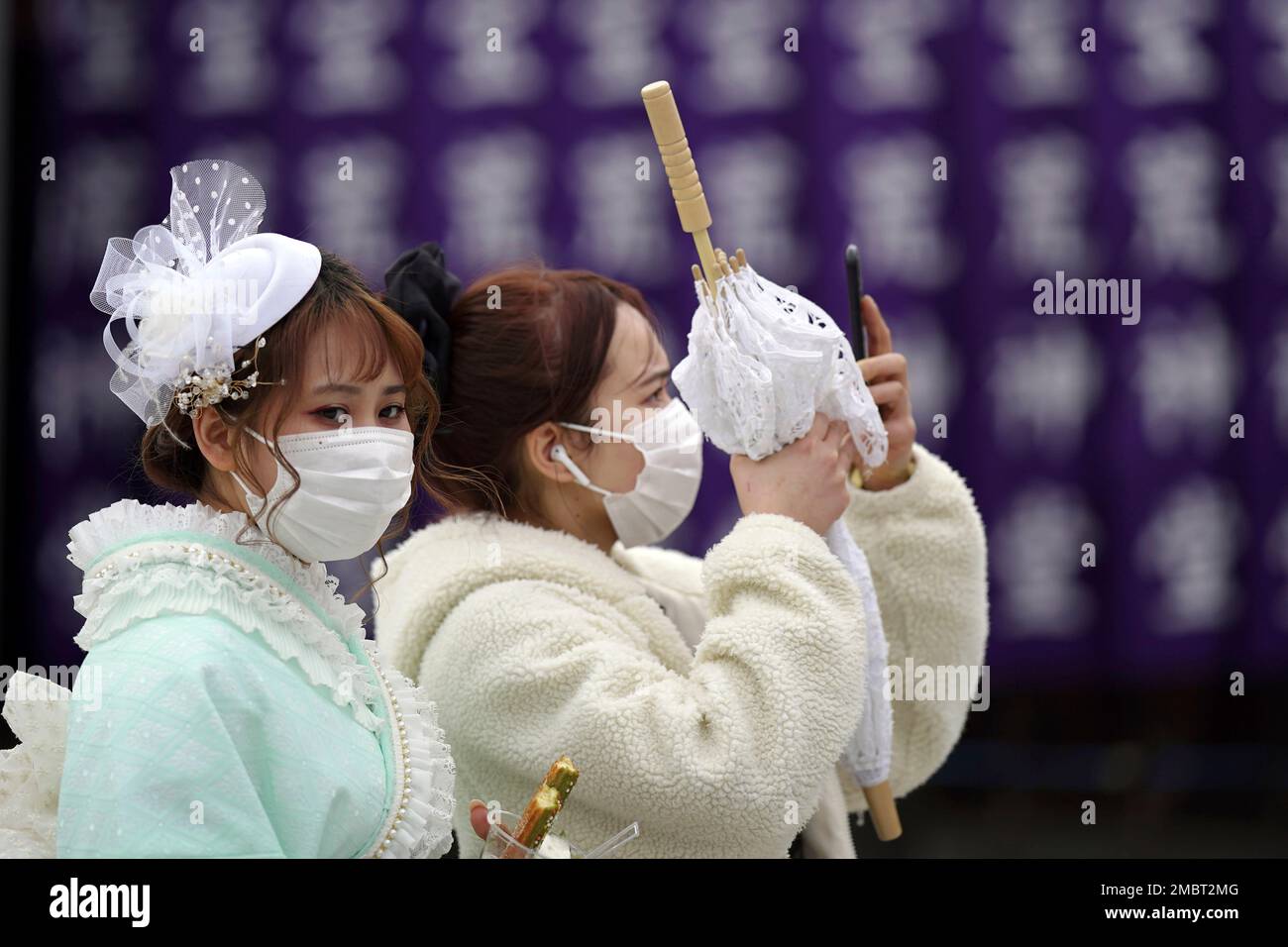 Women wearing face masks clad in a Japanese traditional "kimono" walk ...