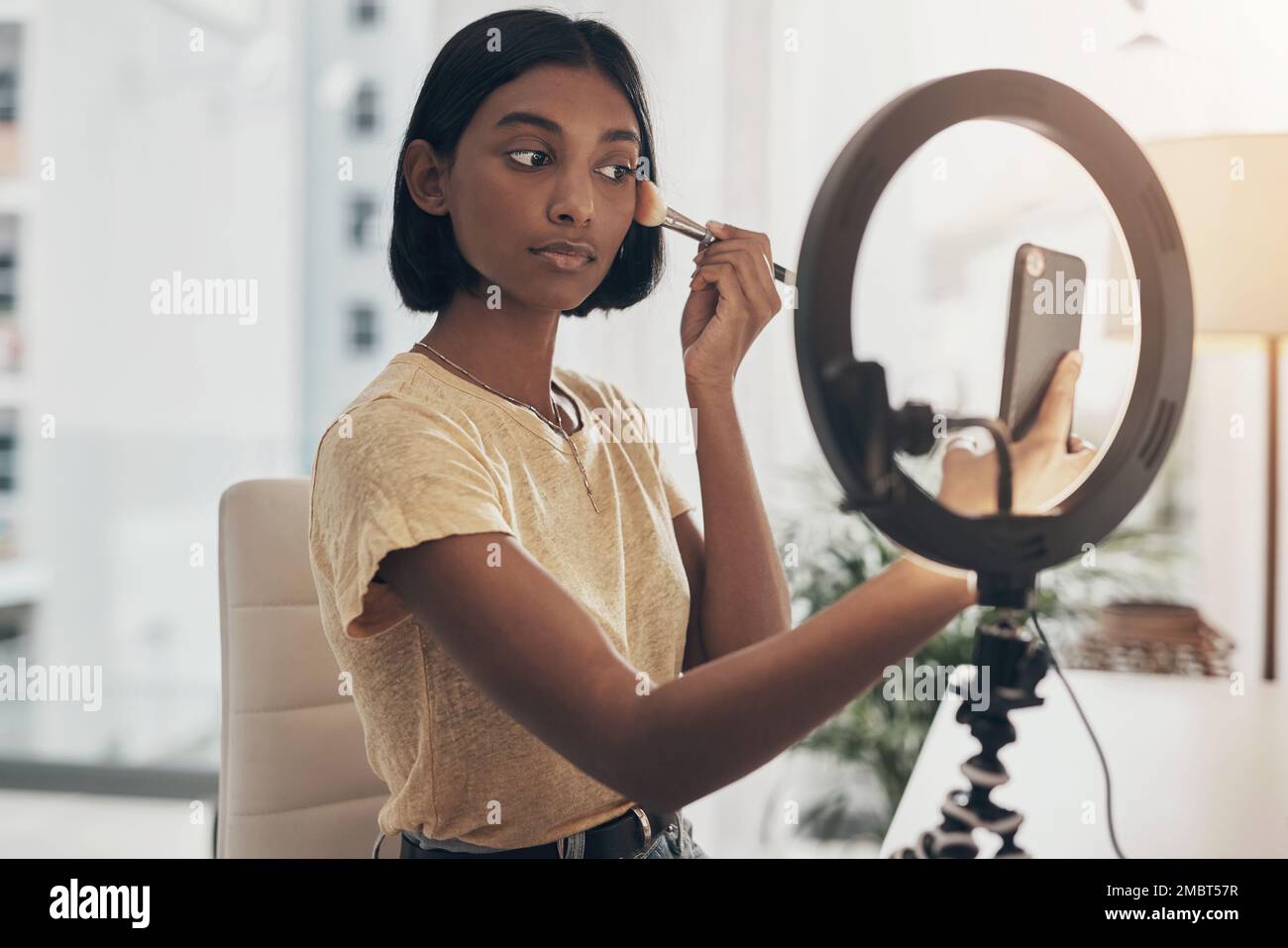 With a good brush comes good makeup. a young woman applying makeup ...