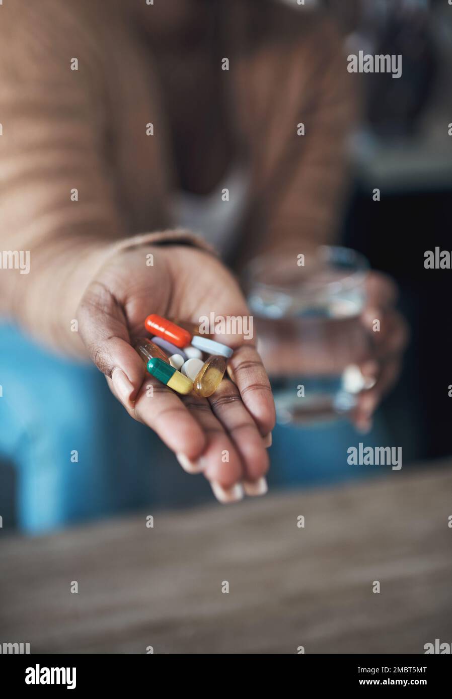My daily dose of vitamins. an unrecognizable woman sitting alone at ...