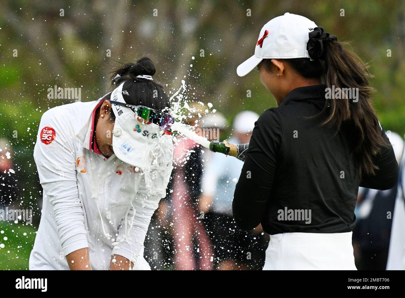 Pajaree Anannarukarn, right, douses Atthaya Thitikul, of Thailand, with champagne after Thitikul ...