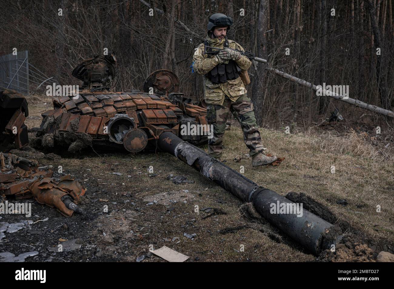 A Ukrainian serviceman walks next to the wreck of a Russian tank in ...