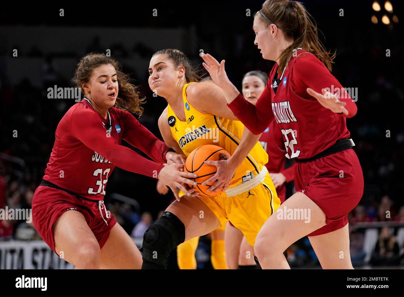 Michigan's Amy Dilk heads to the basket as South Dakota's Kyah Watson ...