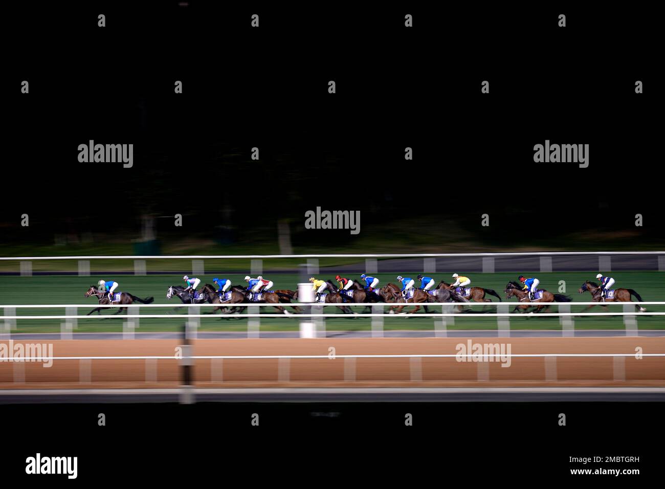 Horses with jockeys race into the first turn in Group 1 Dubai Turf over ...