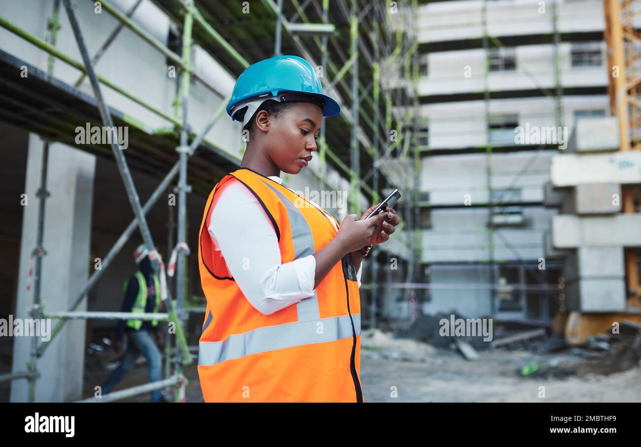 Connected with the field team right from her phone. a young woman using ...