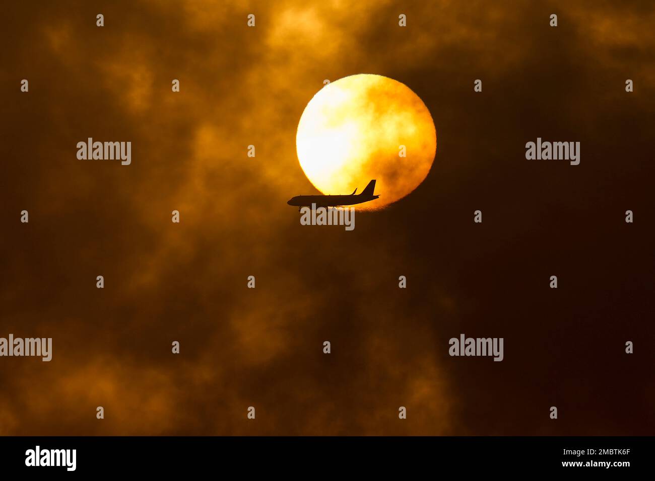 A passenger airplane flies between a smoldering fire at a Saudi Aramco ...