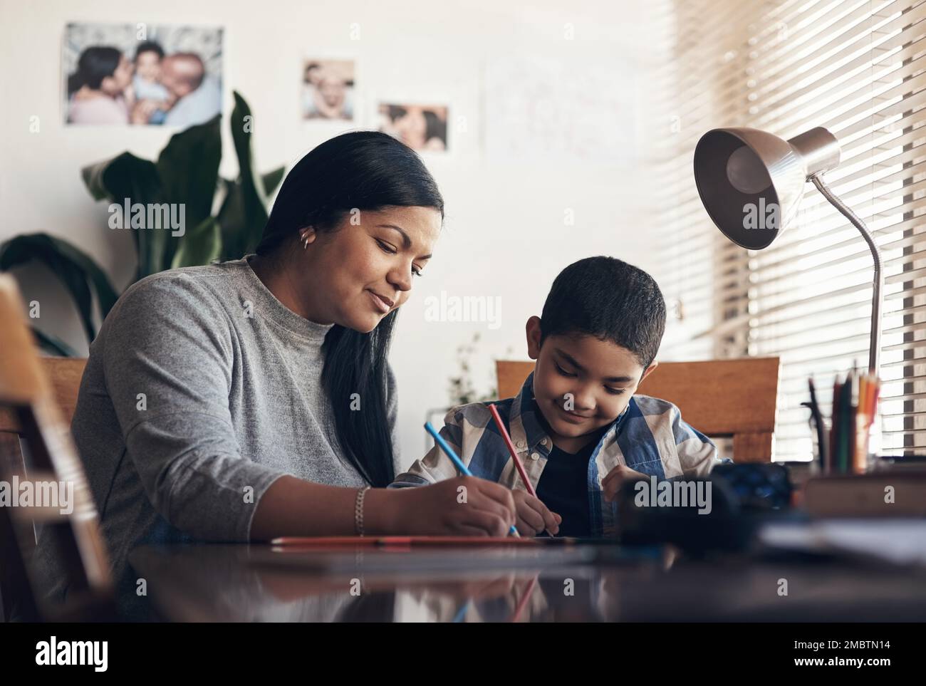 Tackling homework as a team. an adorable little boy completing a school ...