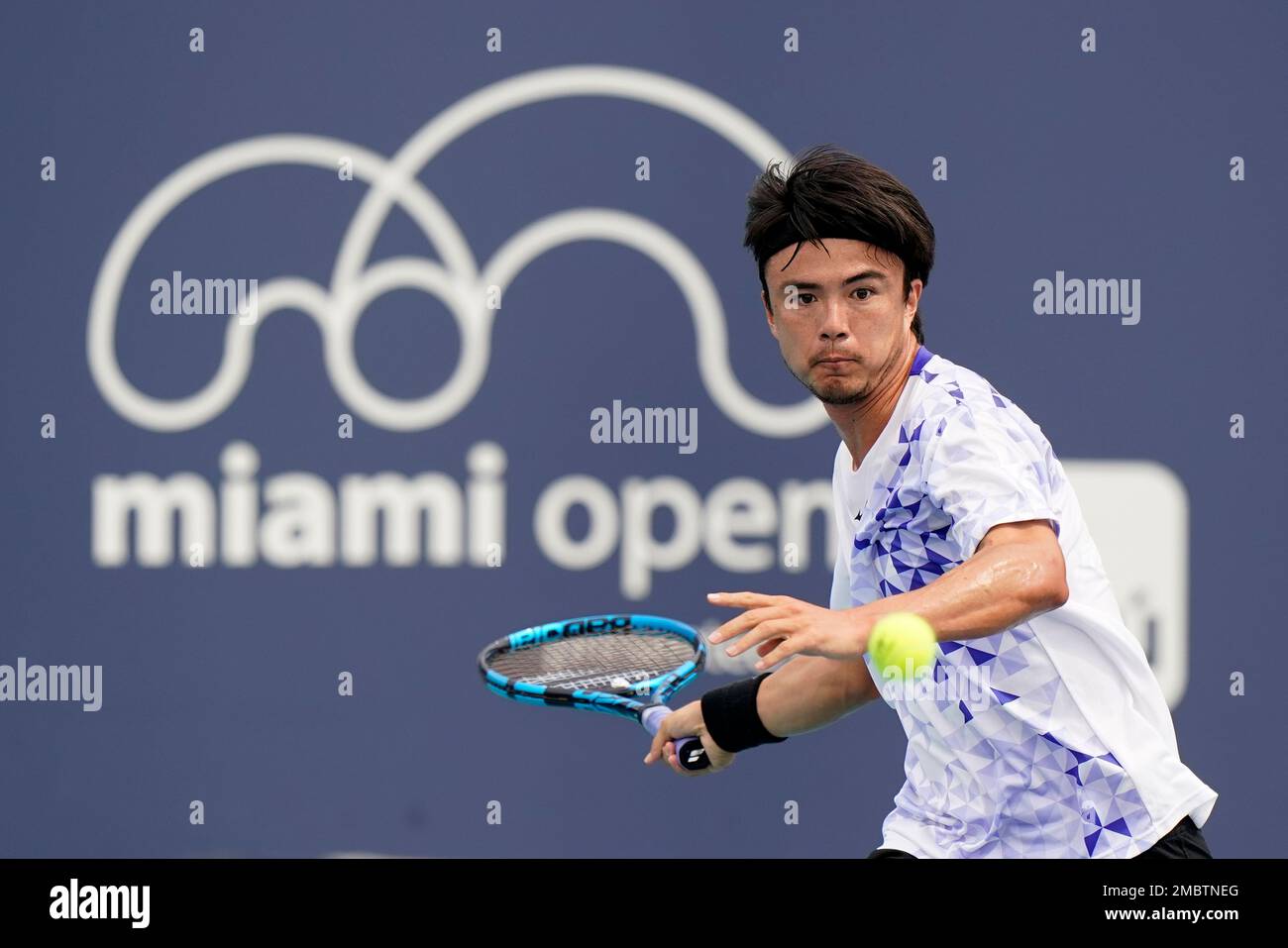 Taro Daniel, of Japan, returns a shot from Fabio Fognini, of Italy ...