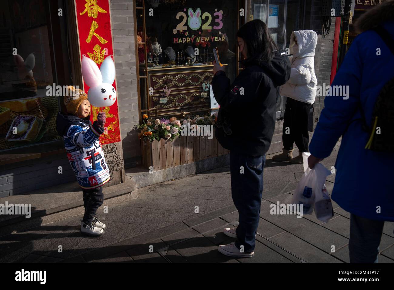 A child poses for photos with a cotton candy in the shape of a rabbit ...