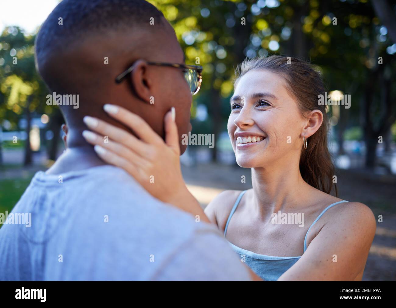 Love, interracial or couple of friends in a park bonding on a romantic ...