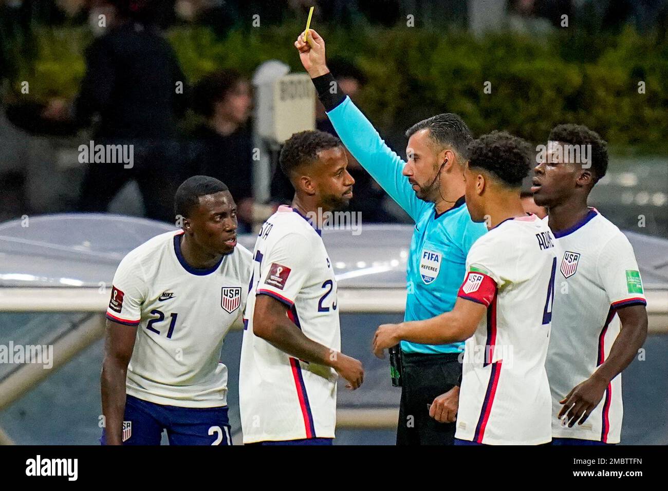 Referee Mario Escobar from Guatemala, shows a yellow card United States ...