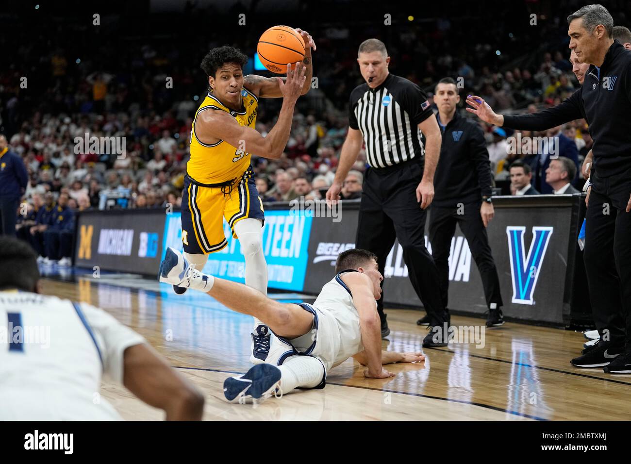 Michigan guard Eli Brooks goes over Villanova guard Collin Gillespie ...