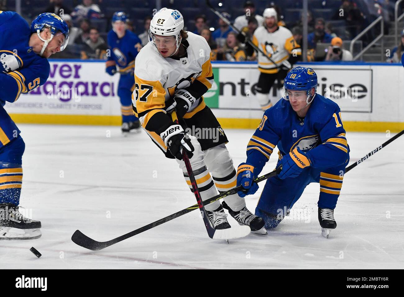 Buffalo Sabres defenseman Henri Jokiharju, right, pokes the puck away ...