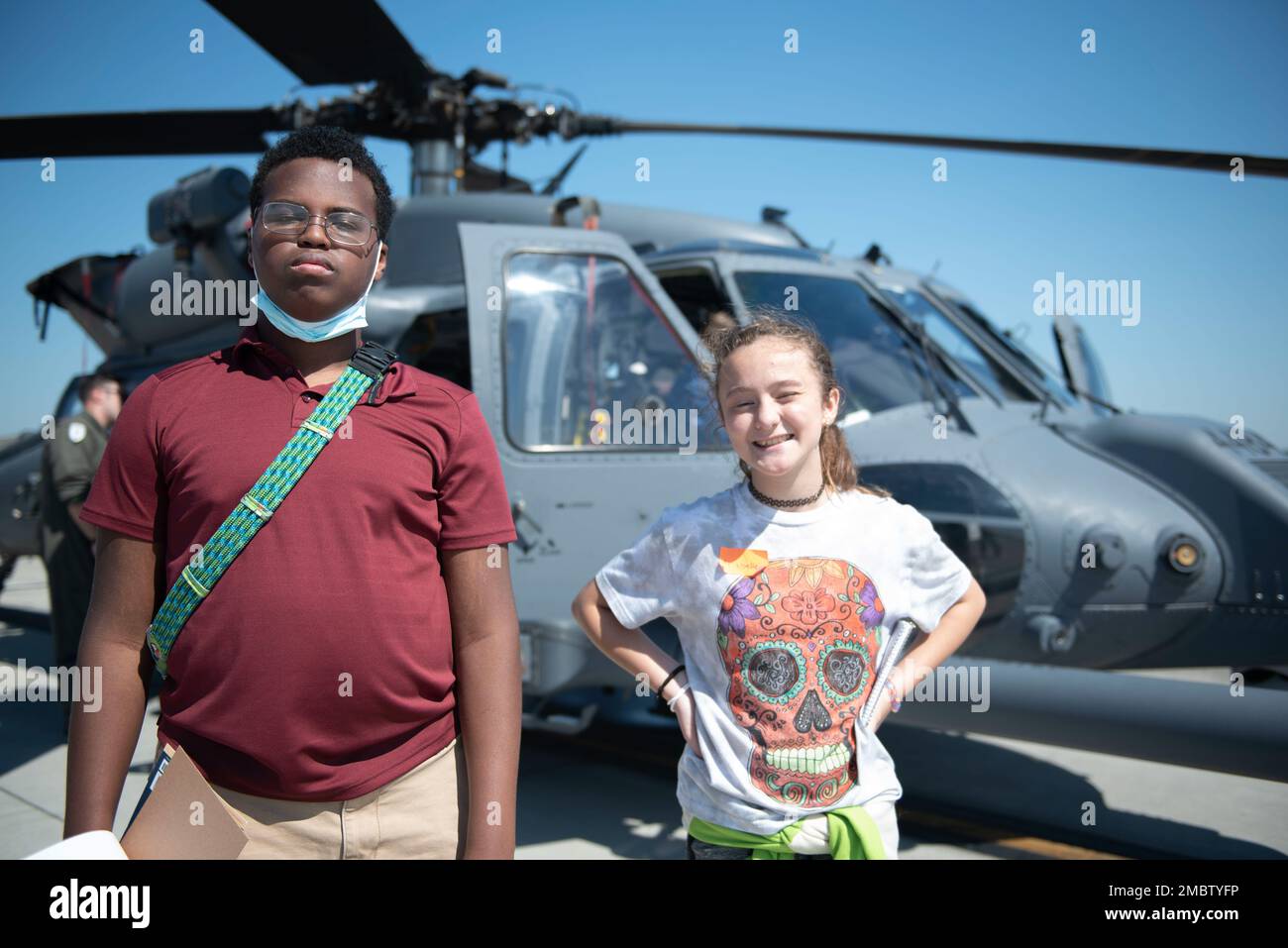 Nicolas, left, and Annabelle, right,pose in front of an HH-60W Jolly ...