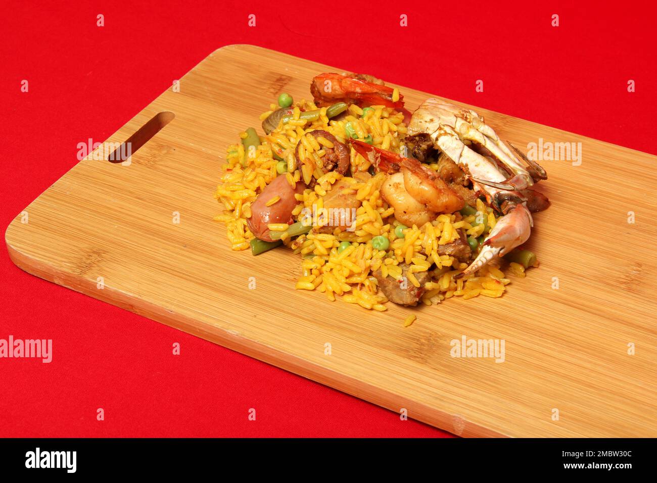 Dish from Valencia Spain Arroz a la paella on a wooden board in a red ...