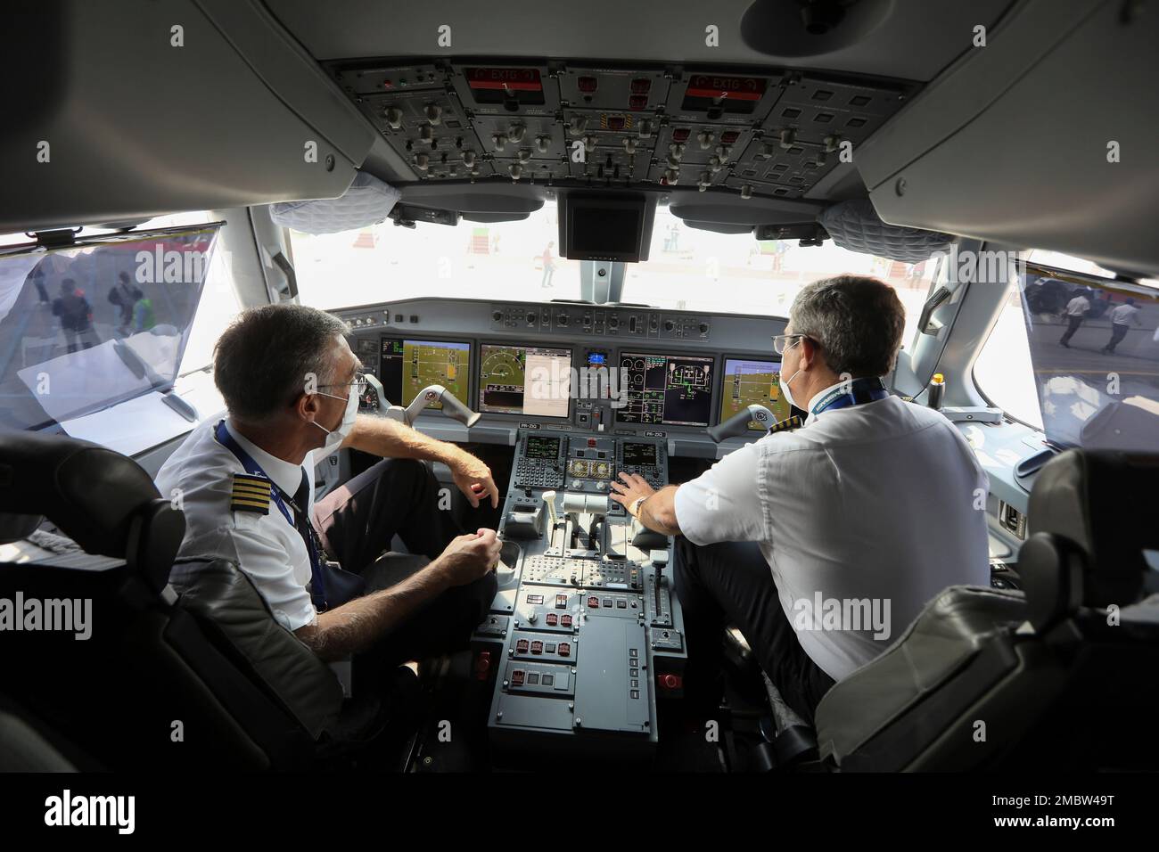 Pilots sits inside the cockpit of an Embraer E195-E2 aircraft on static ...