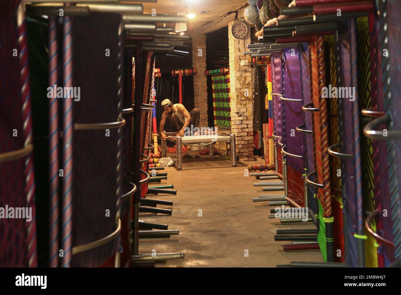 A craftsman assembles a traditional cot, locally called 'Charpai', at ...