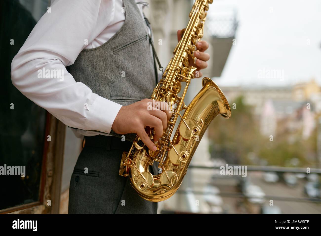 Saxophonist playing music outdoors, closeup saxophone in musician hand ...