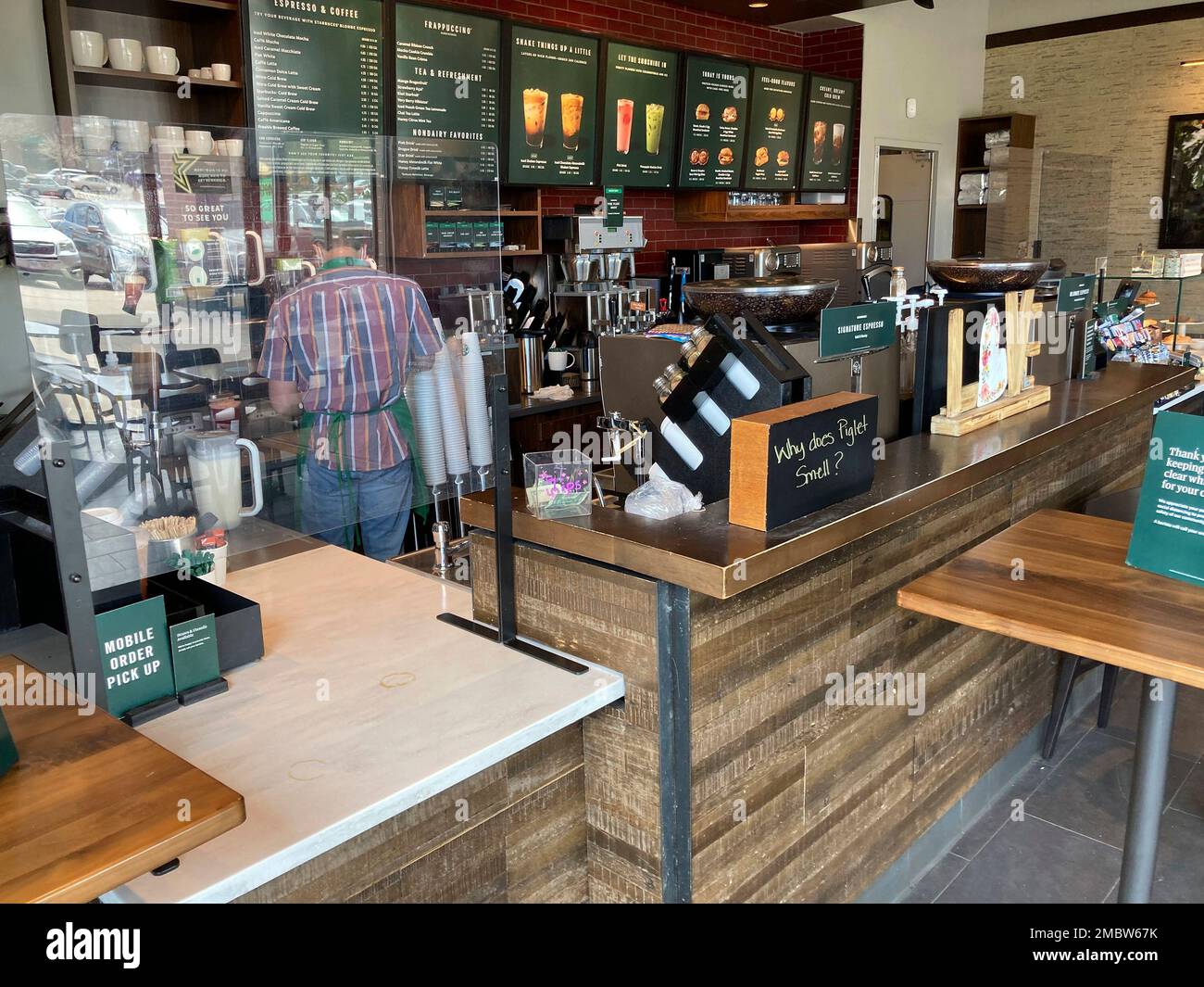 A lone barista works behind the counter of a Starbucks in a storefront ...