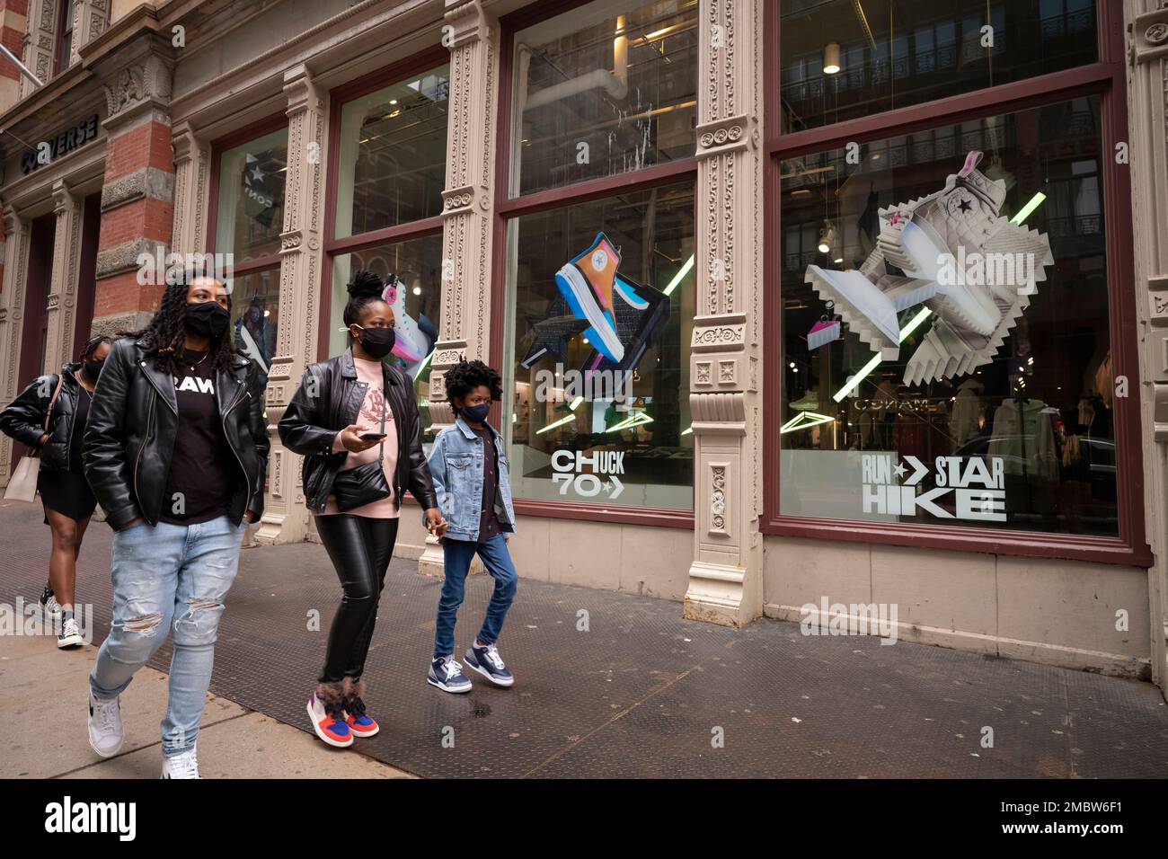 People walk by a Converse sneaker store, Thursday, March 25, 2021, in ...