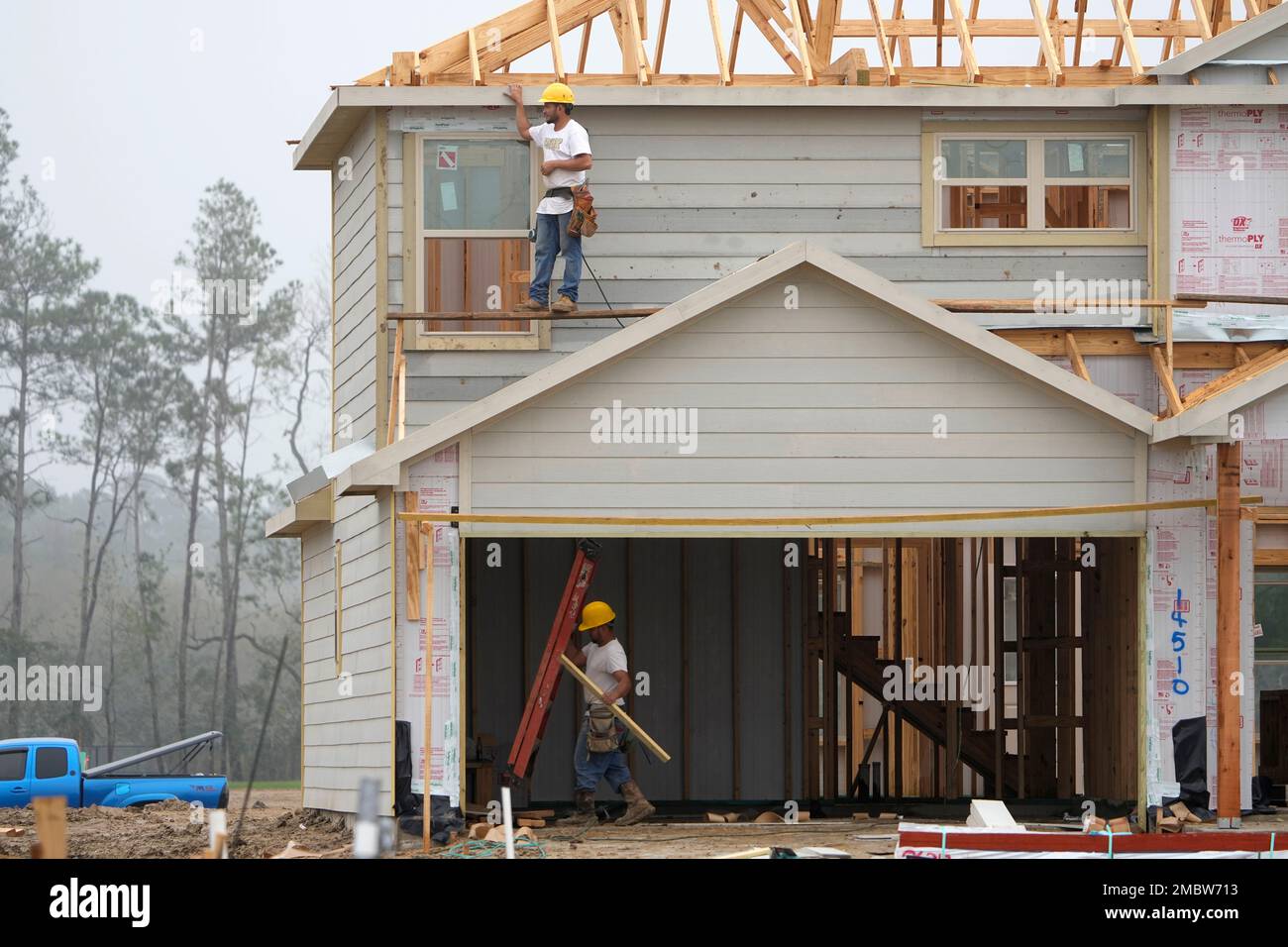 Construction workers build a new home Monday, March 15, 2021, in ...